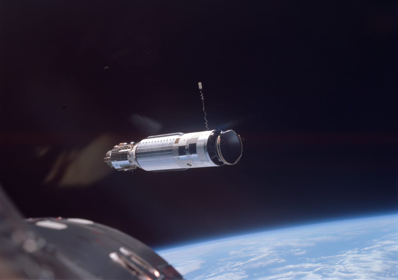 High above Earth, the Agena target vehicle is photographed 55 feet from ...