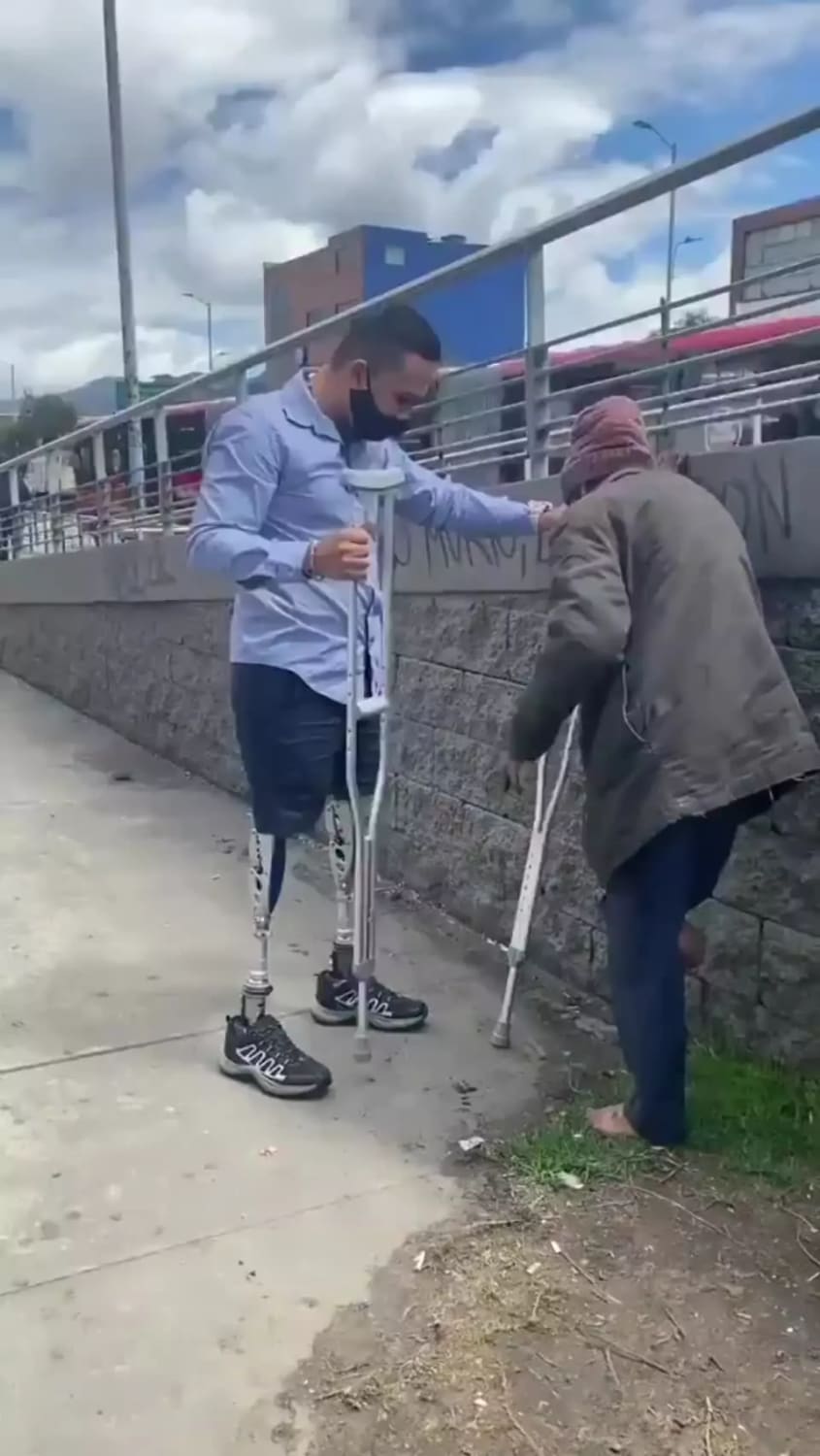 Double amputee with prosthetics gives his crutches to a homeless amputee.