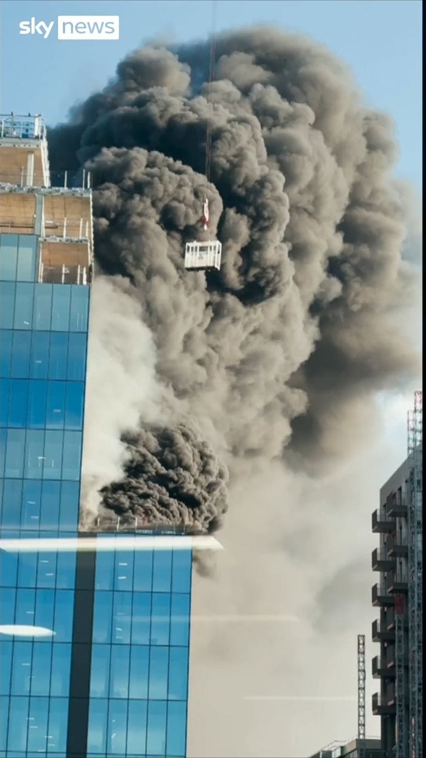 Quick-thinking crane operator rescues a man stuck on a burning building
