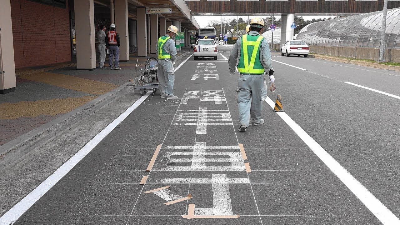 Roadworkers in Japan apply road markings outside the terminal of Aomori ...